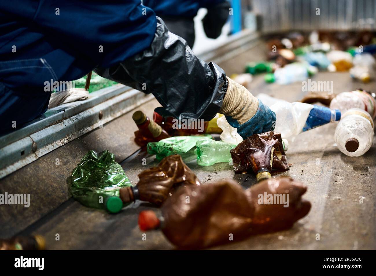 Worker sorts trash on conveyor belt at waste recycling plant Stock Photo - Alamy