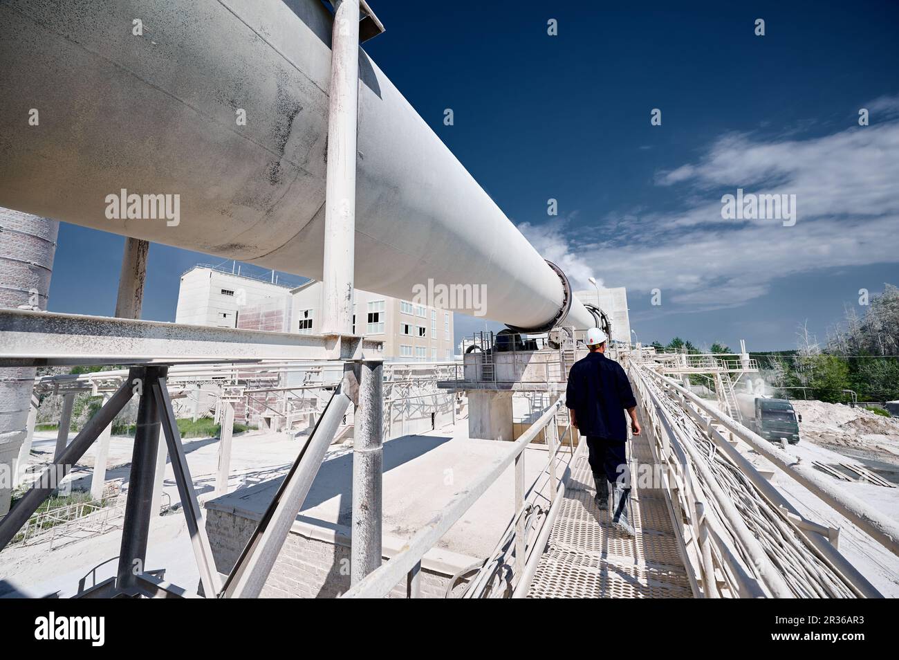 Worker walks along ladders for maintenance of rotary kiln Stock Photo ...