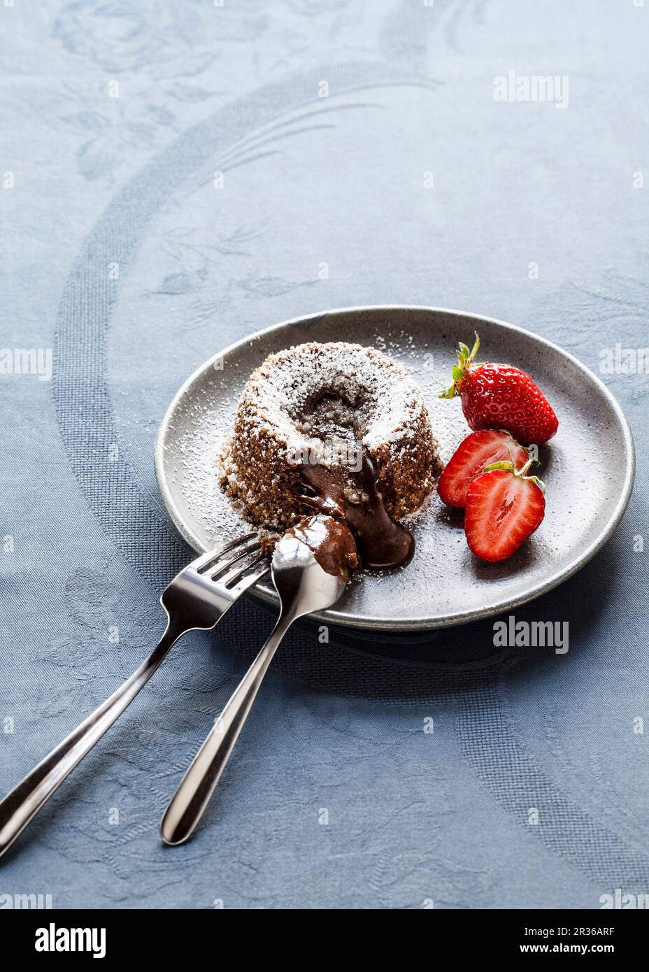 Warm chocolate cake with a liquid core dusted with icing sugar and ...