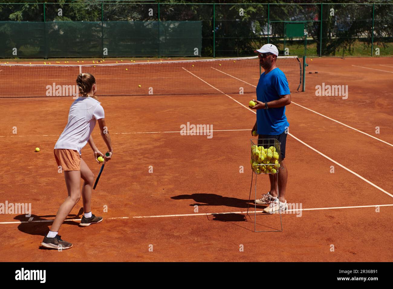 A professional tennis player and her coach training on a sunny day at ...