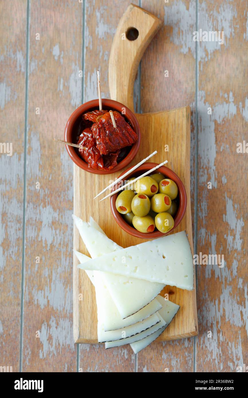 Triangles of Spanish cheese, stuffed olives and dried tomatoes (Spain ...