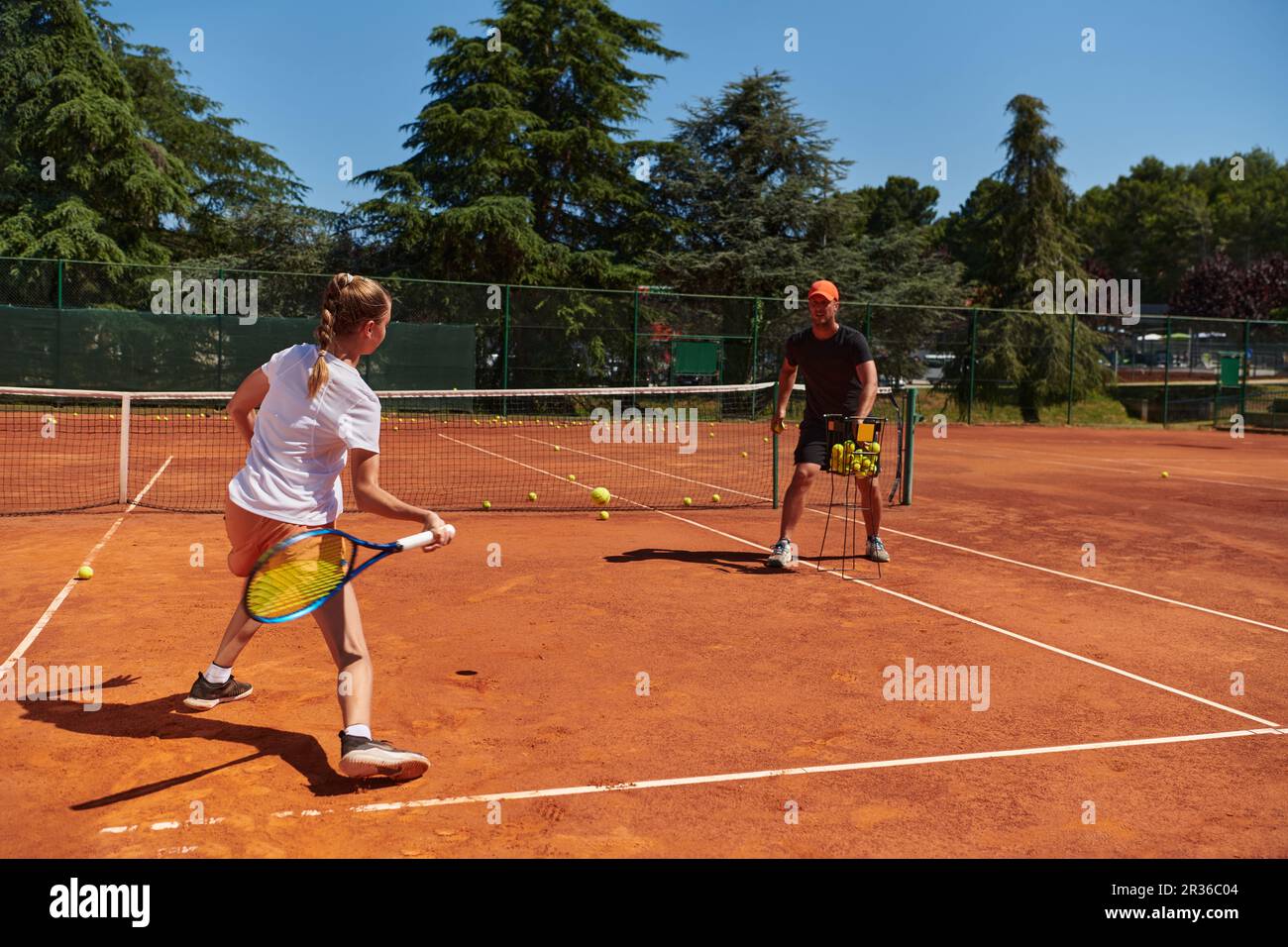 A professional tennis player and her coach training on a sunny day at ...