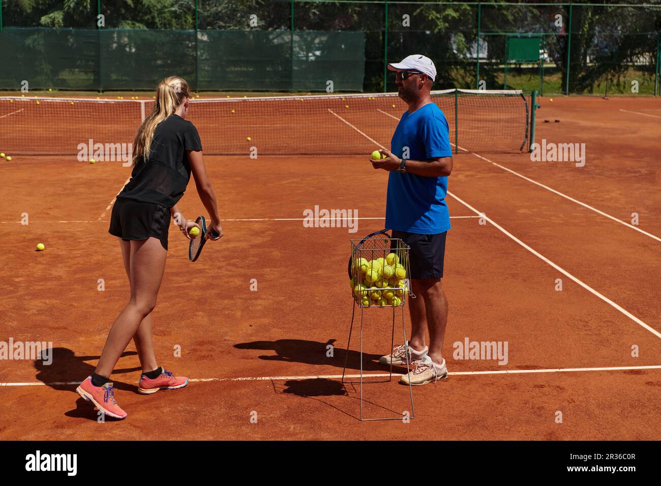 A professional tennis player and her coach training on a sunny day at ...