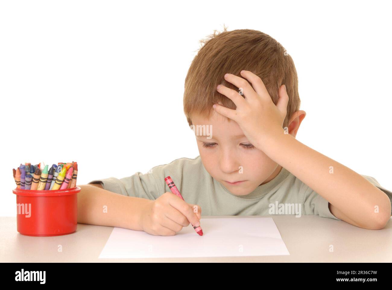 Young Boy coloring a sheet of paper with a crayon Stock Photo - Alamy