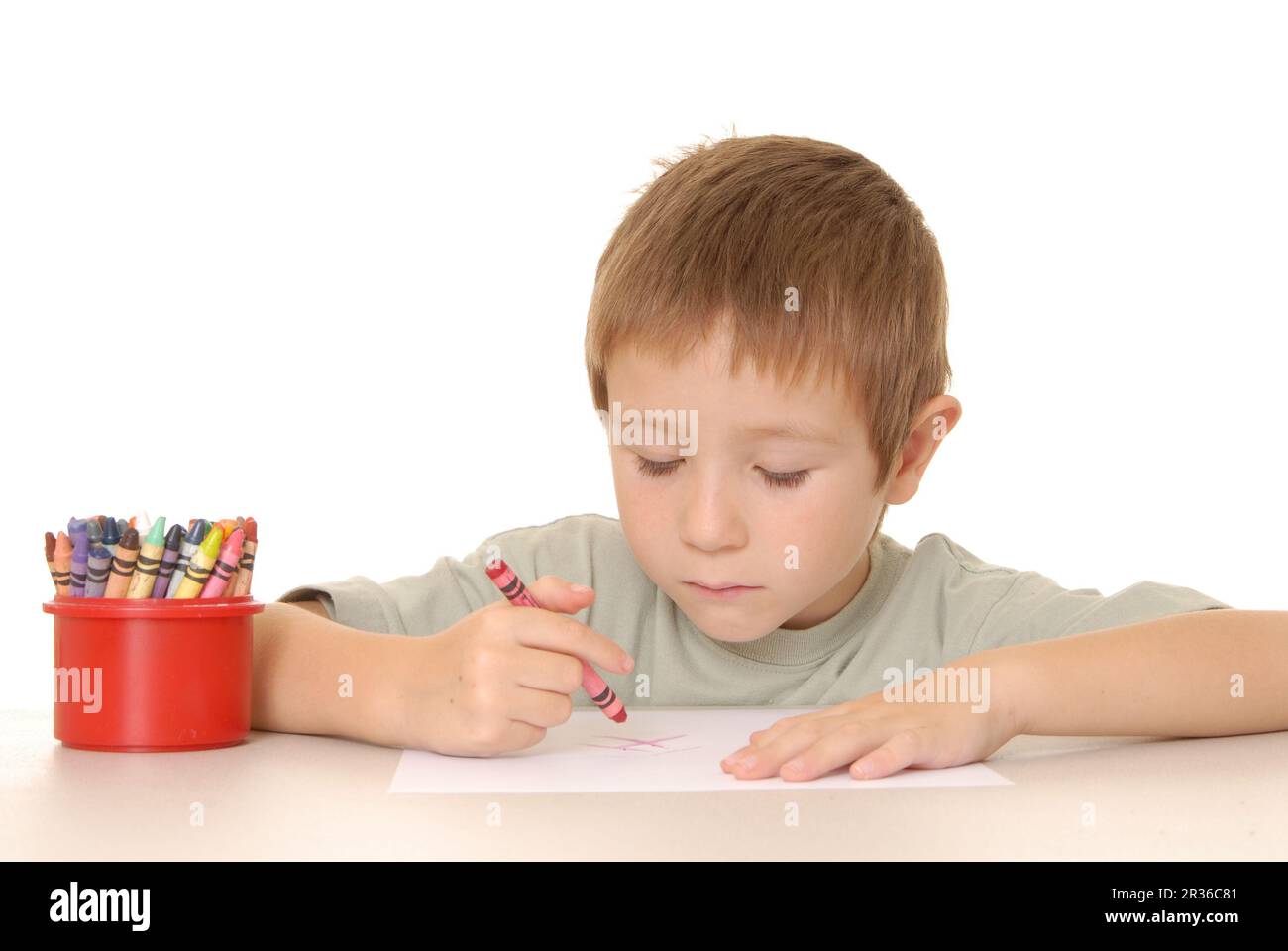 Young Boy coloring a sheet of paper with a crayon Stock Photo - Alamy