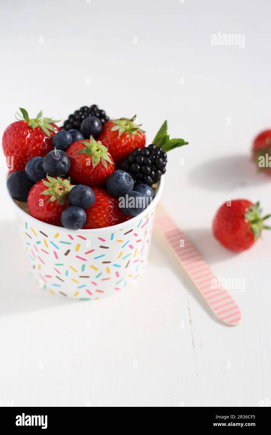 Various berries in a colourful tub Stock Photo - Alamy