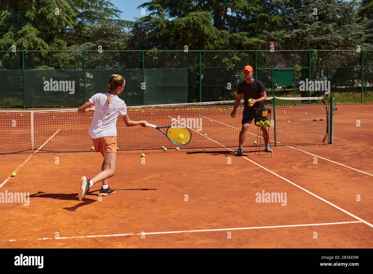 A professional tennis player and her coach training on a sunny day at ...