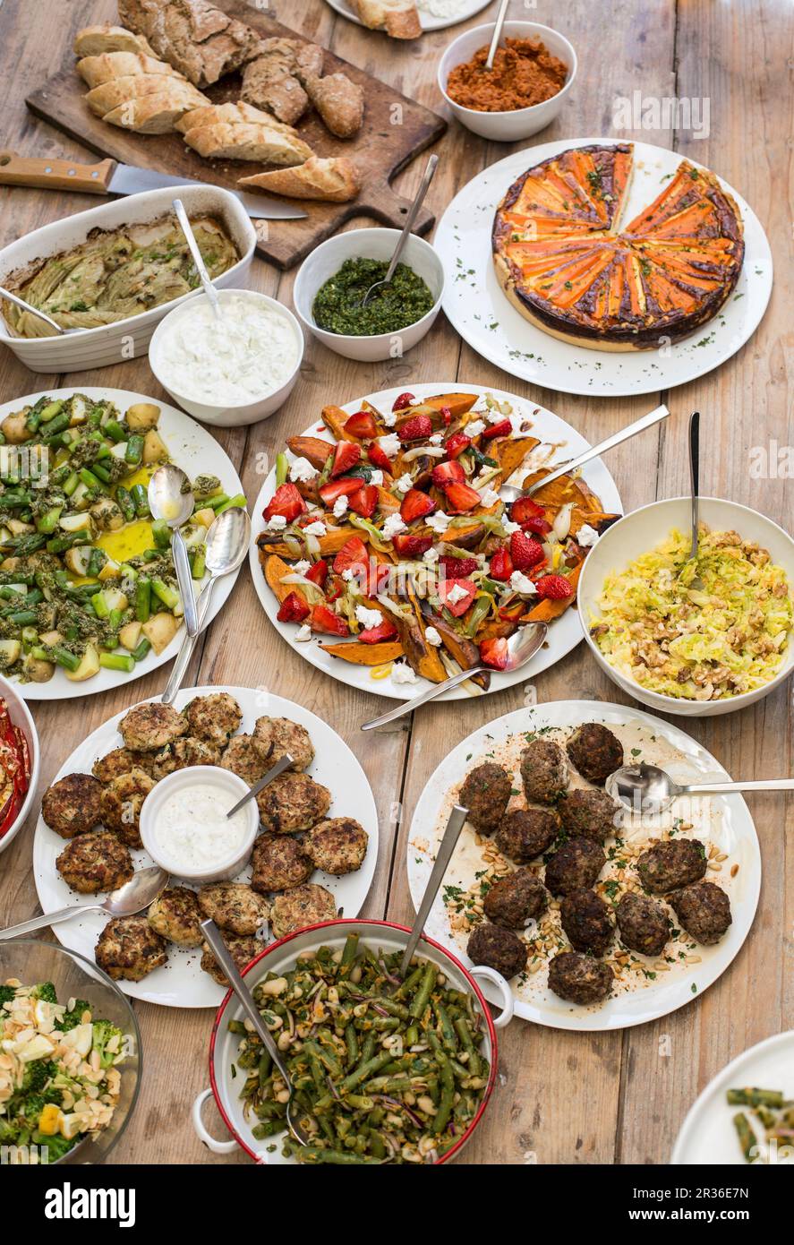 Various dishes and bred on a rustic buffet Stock Photo - Alamy