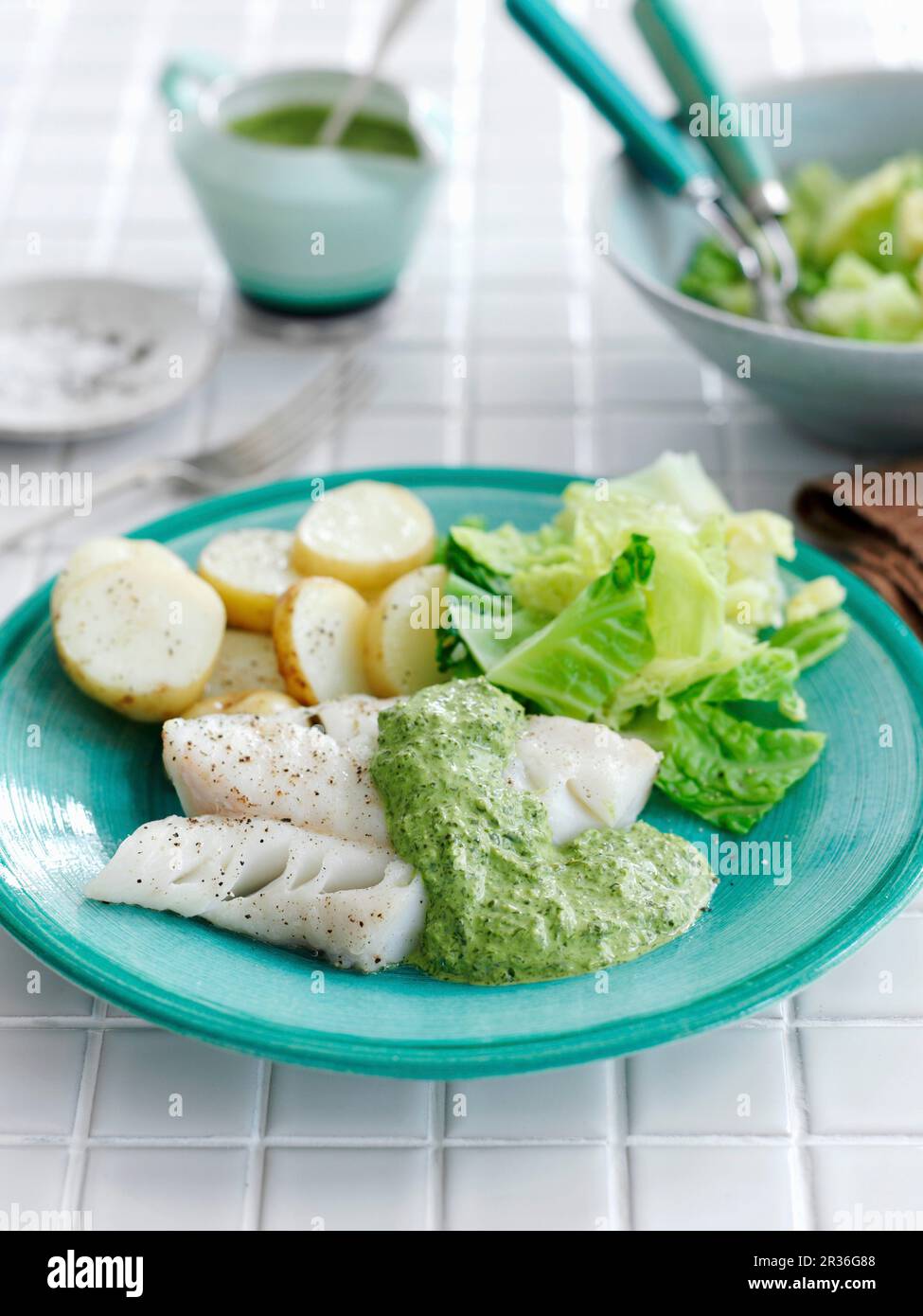 Grilled cod with a cress sauce and potatoes Stock Photo - Alamy