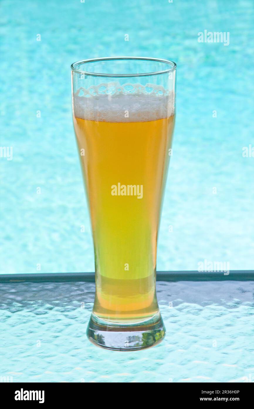 A glass of cold beer by a swimming pool Stock Photo - Alamy