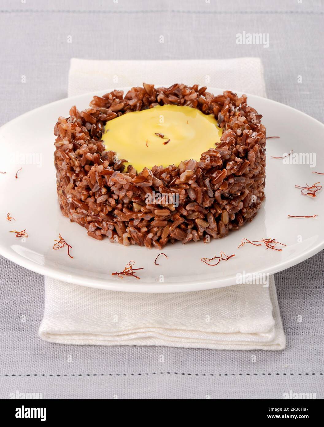 Red rice with a saffron cheese cream Stock Photo - Alamy