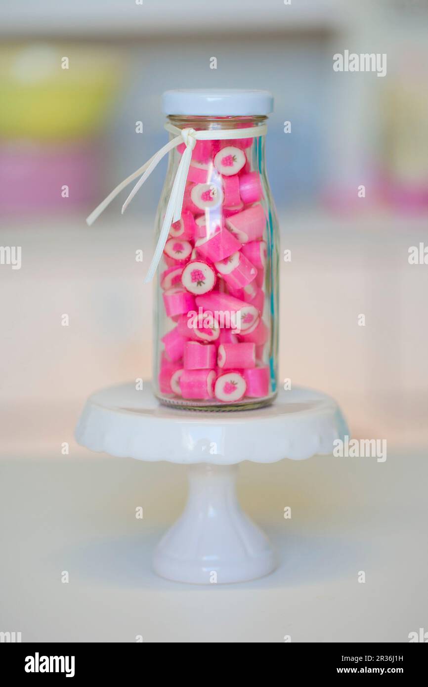 Raspberry sweets packed in a small glass bottle Stock Photo - Alamy
