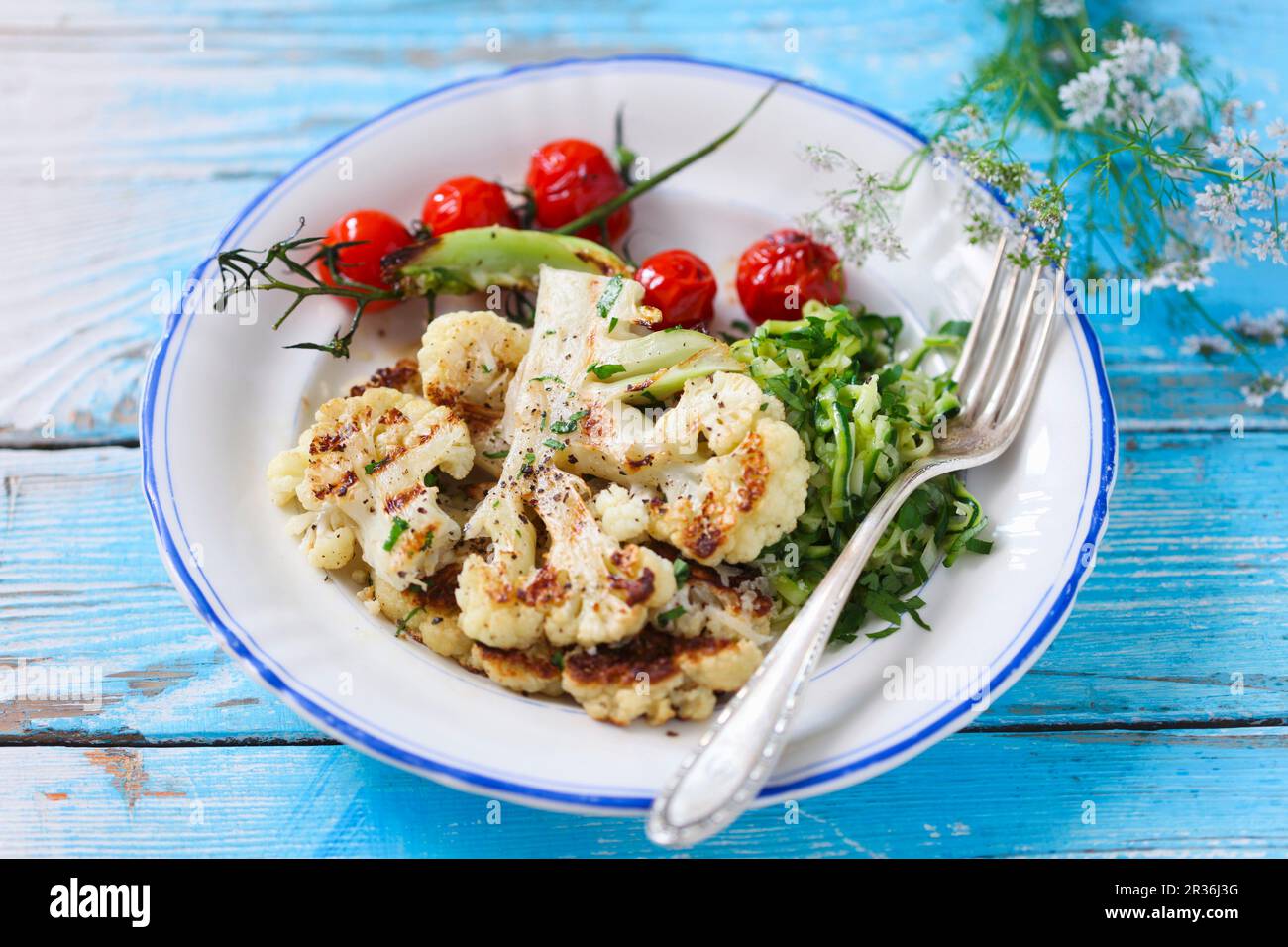 Cauliflower steak with courgette noodles Stock Photo - Alamy