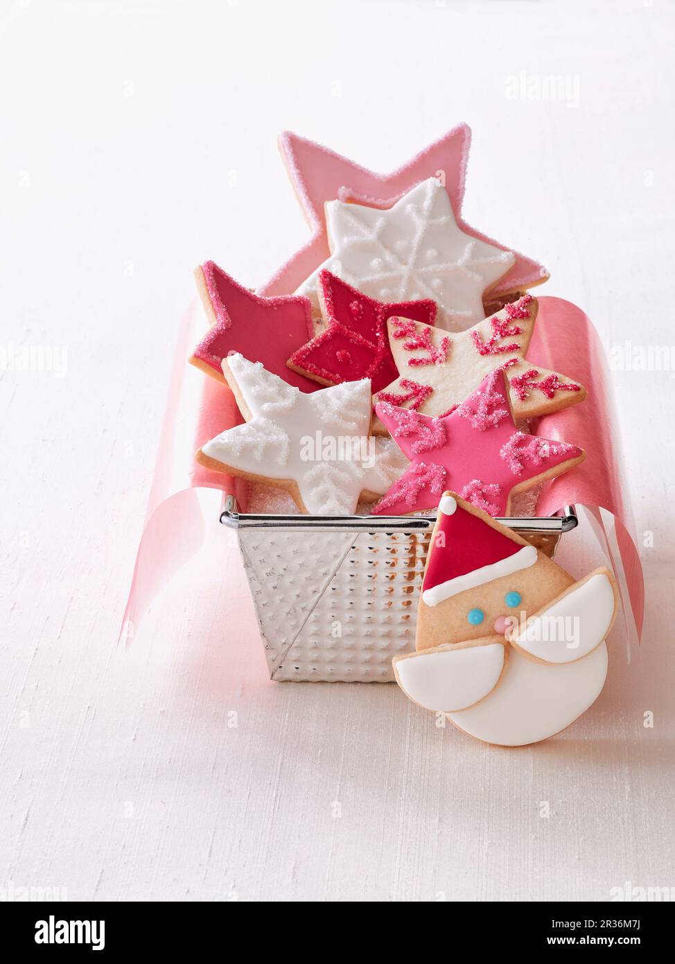 Star shaped Christmas biscuits in a loaf tin next to a Father Christmas ...
