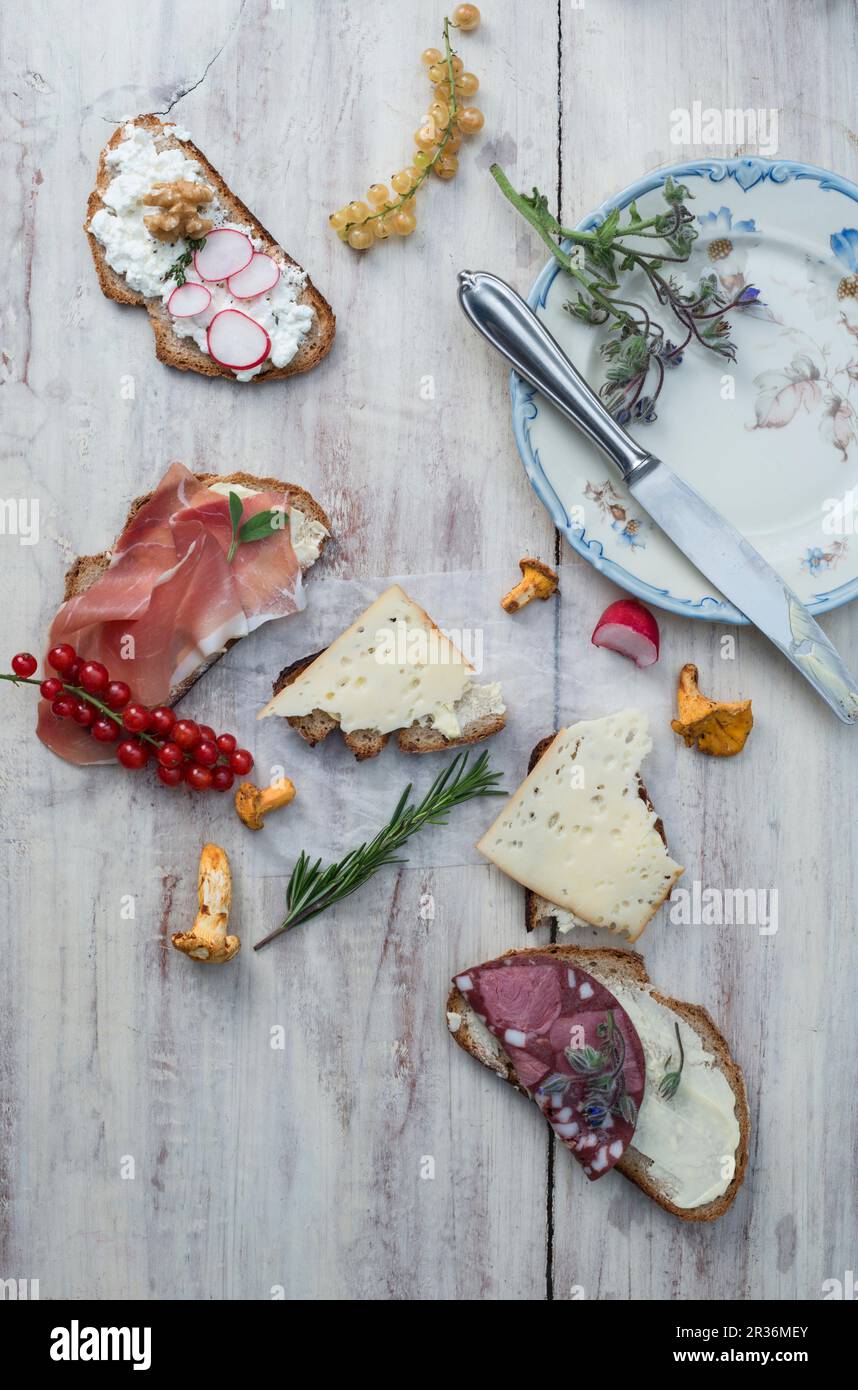 Various slices of bread with different toppings on a white wooden ...