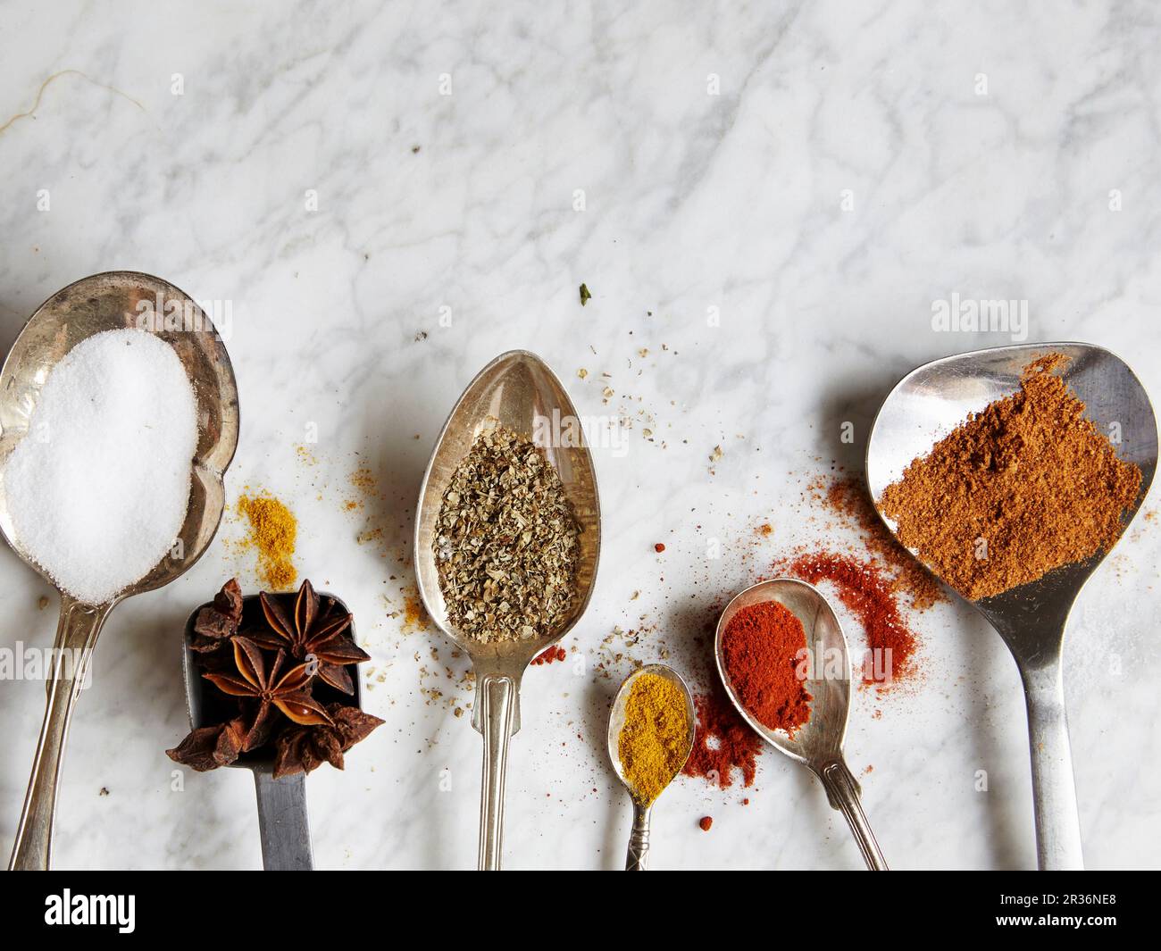 Spoons with assorted spices on a marble surface Stock Photo - Alamy