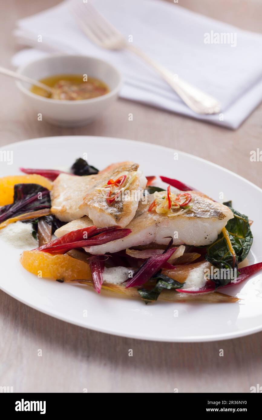 Fillet of fish with chard and orange segments Stock Photo - Alamy