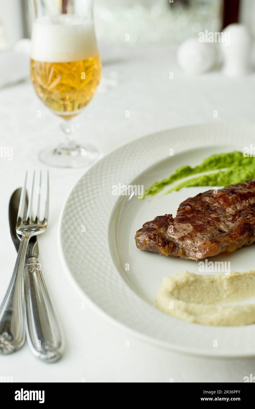 Grilled beef steak with celery puree and pea puree Stock Photo - Alamy