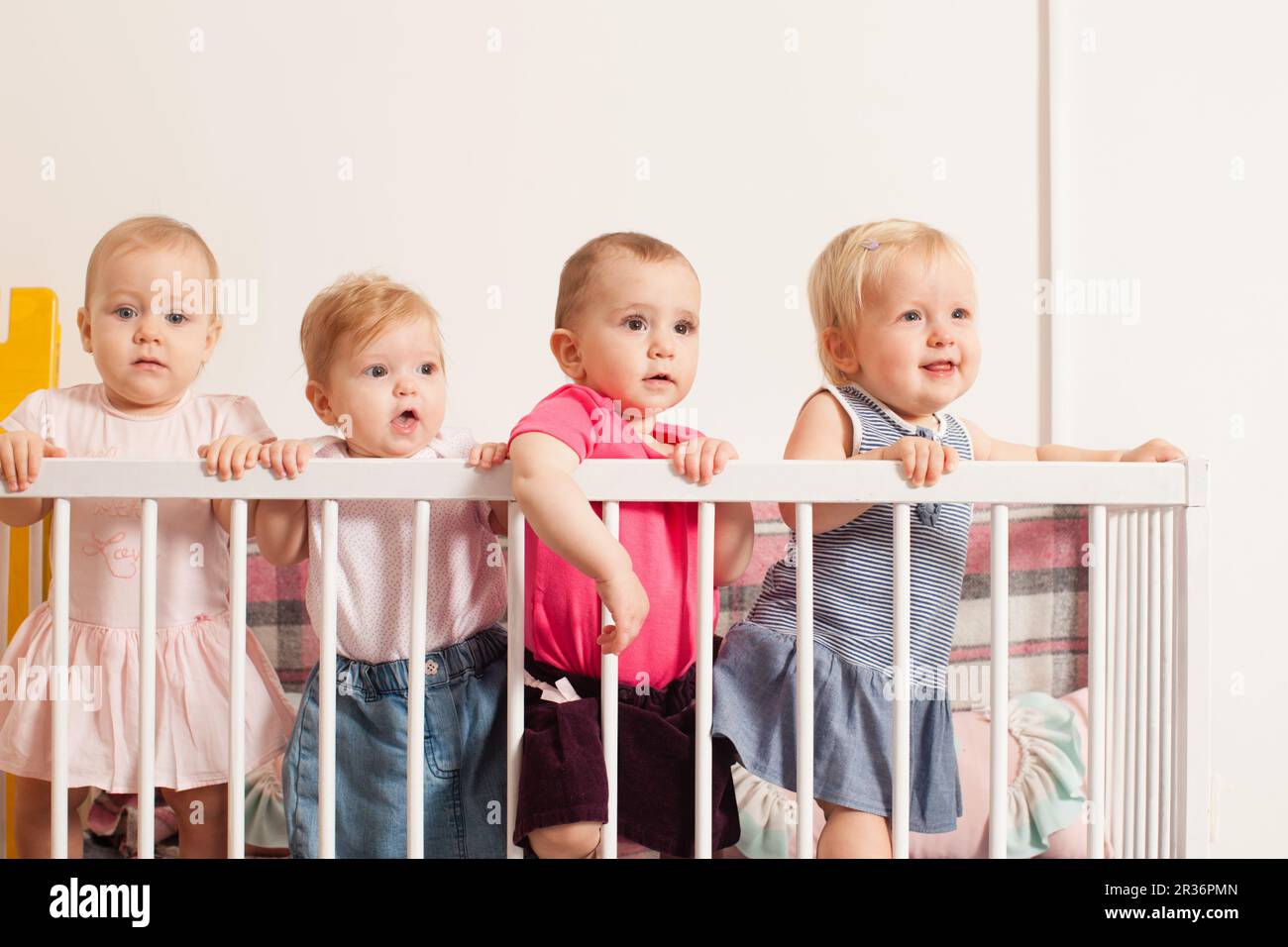 Three baby girls in the crib Stock Photo - Alamy