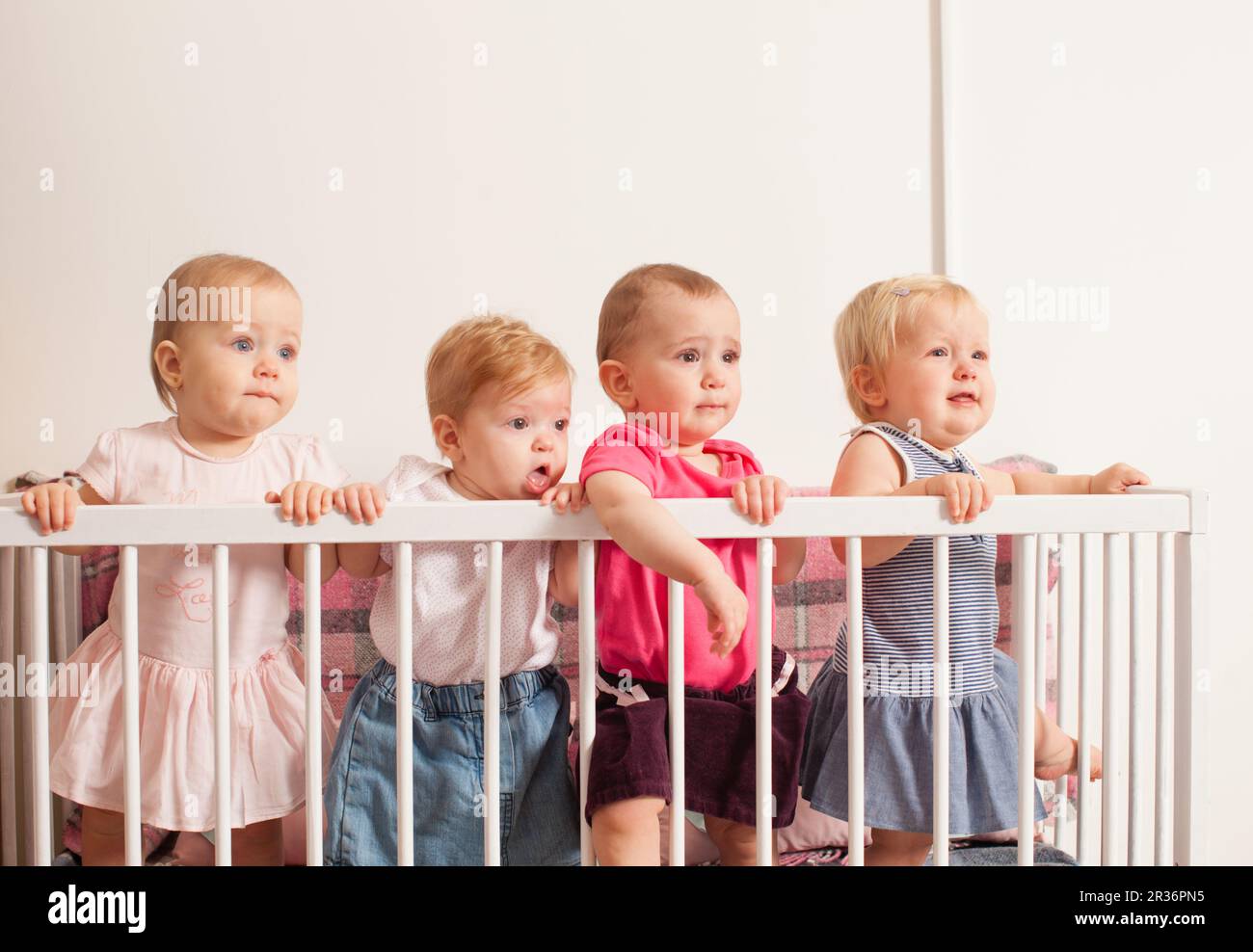 Three baby girls in the crib Stock Photo - Alamy