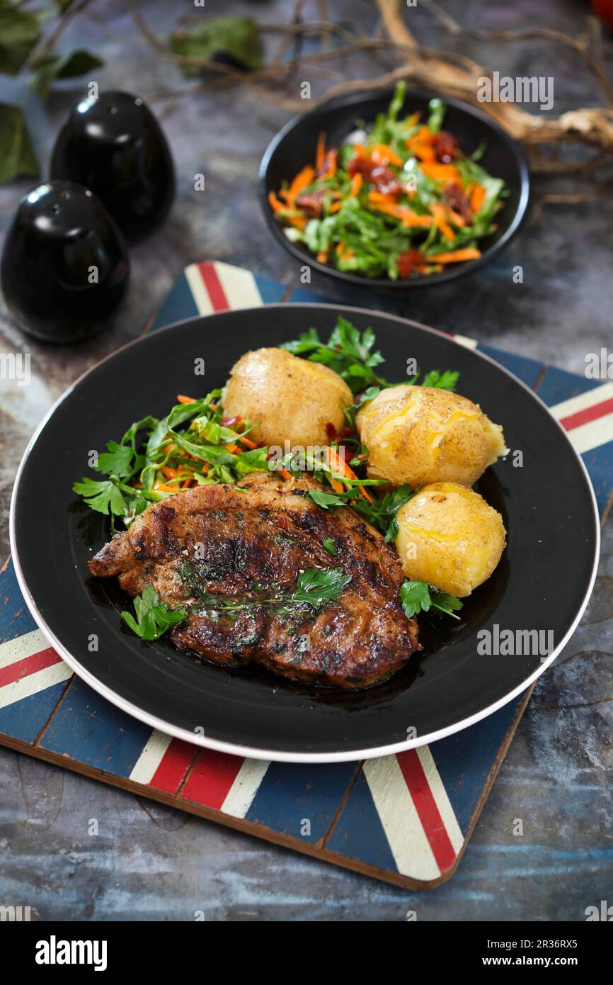 Grilled pork collar steak with new potatoes Stock Photo - Alamy