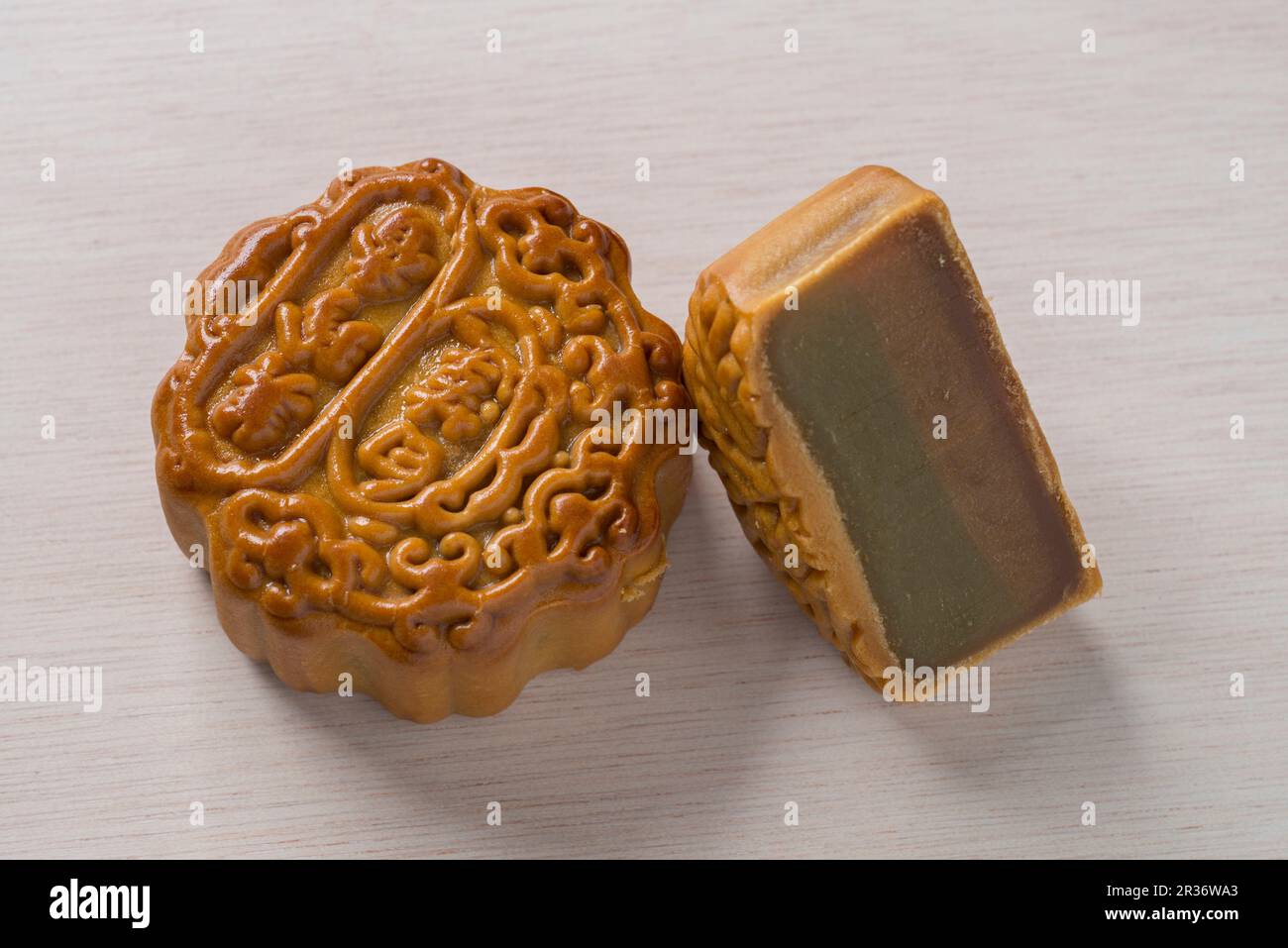 Two Chinese mooncakes, one whole and one cut in half Stock Photo - Alamy