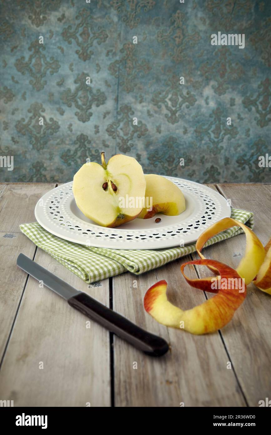 A peeled apple cut in half on a plate Stock Photo - Alamy