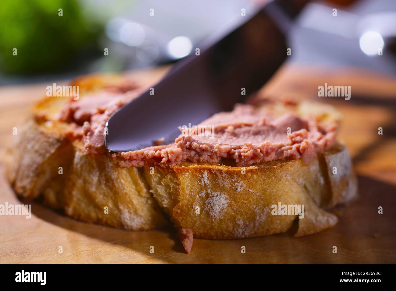 Liver pâté being spread on a slice of baguette Stock Photo - Alamy