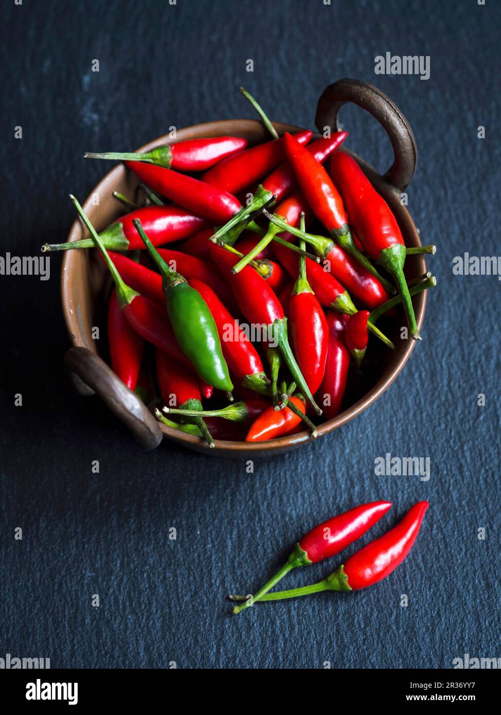 Small chilli peppers in a copper bowl on slate Stock Photo - Alamy