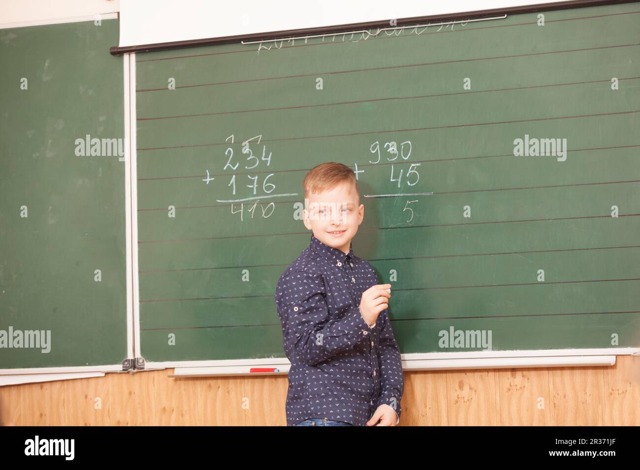 School boy solves examples at the board Stock Photo - Alamy