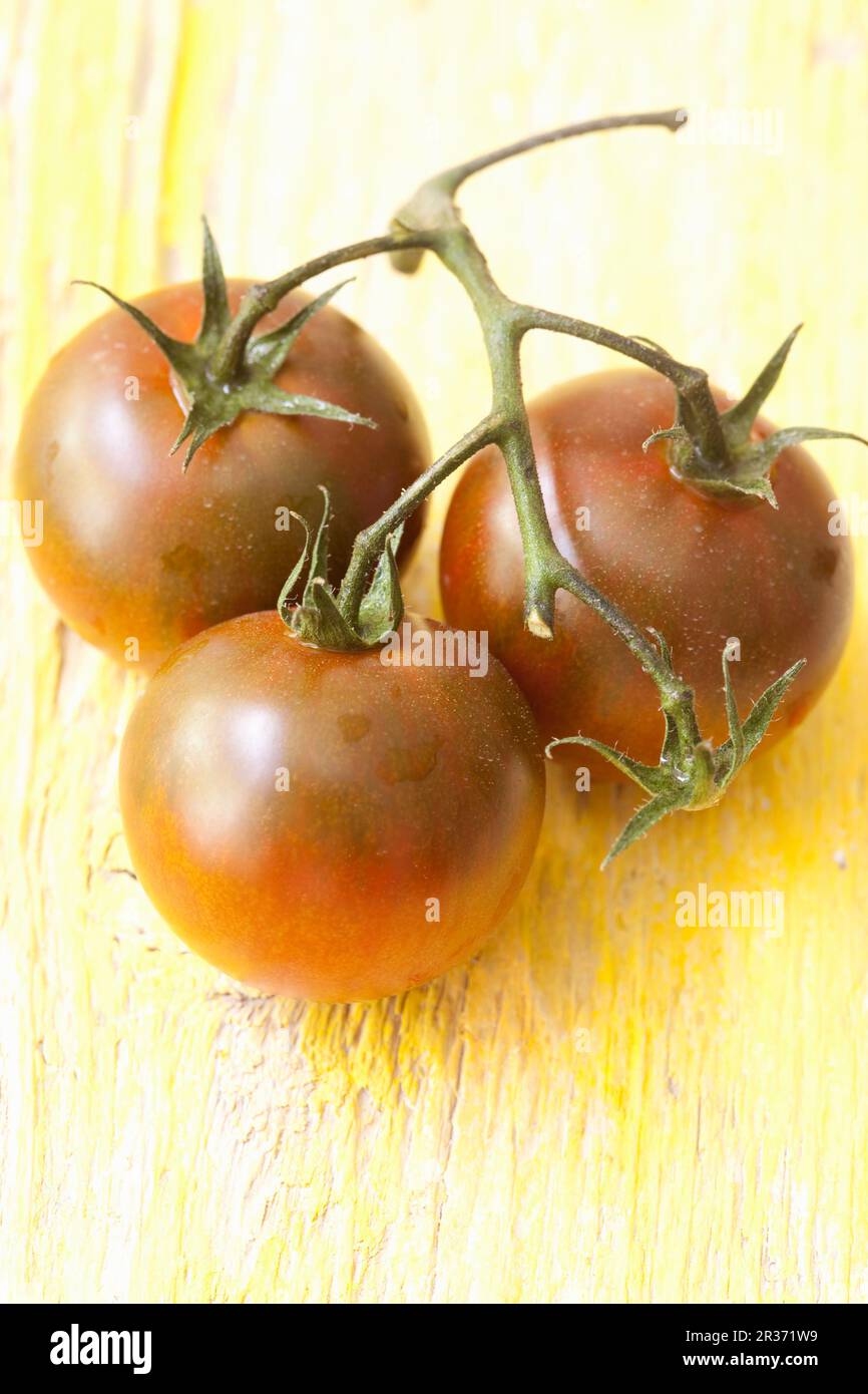 Organinc green zebra tomatoes on the vine Stock Photo - Alamy