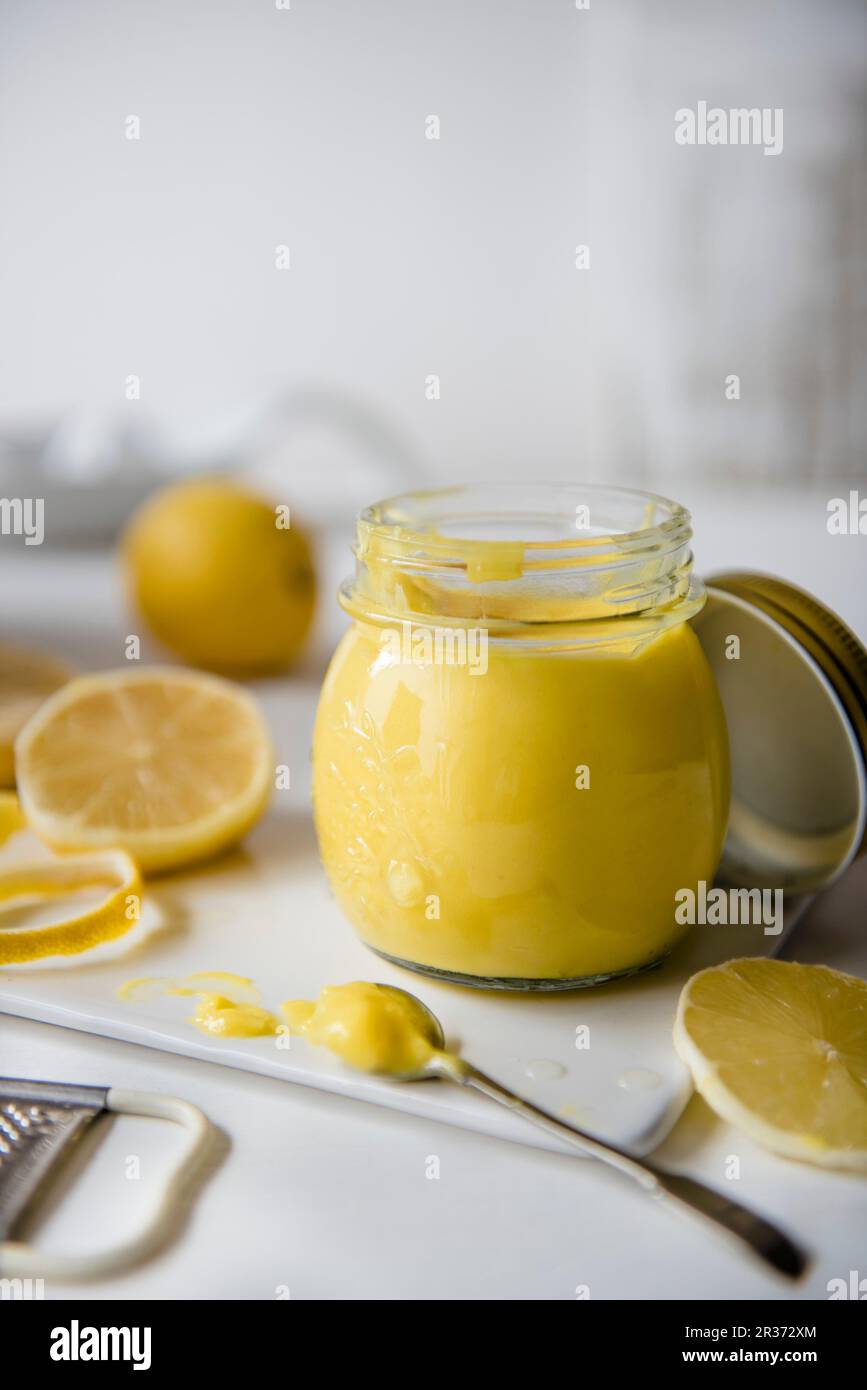 Lemon curd in a jar with fresh lemons Stock Photo - Alamy