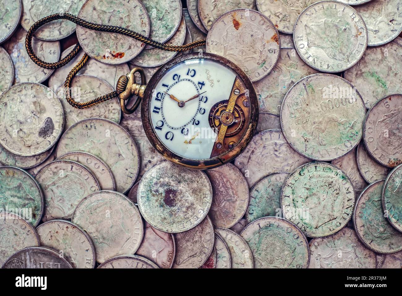 A bunch of old silver coins with a broken pocket watch on top Stock ...