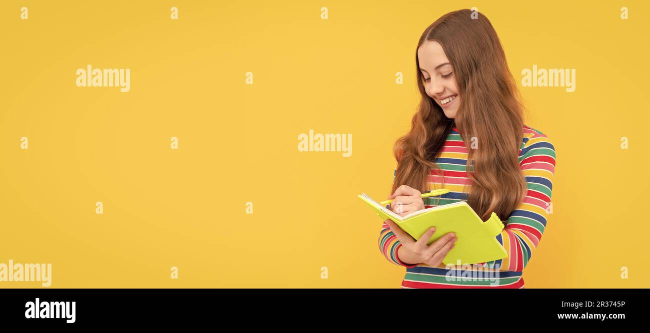 Happy girl child write down in copybook yellow background, literacy ...