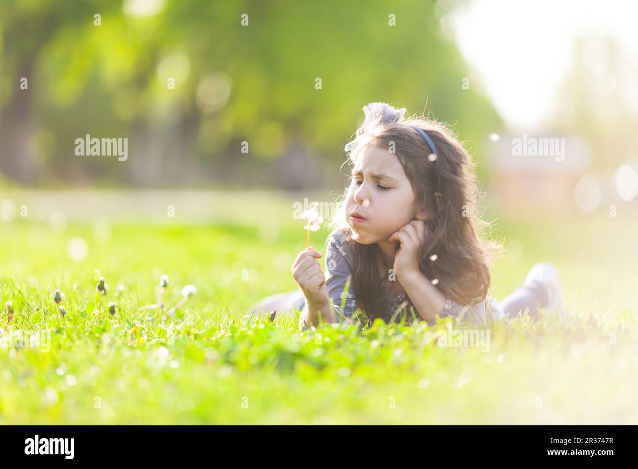 Cute girl blowing dandelion Stock Photo - Alamy