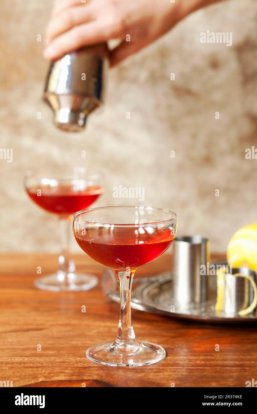 A cocktail being poured from a shaker into glasses Stock Photo - Alamy