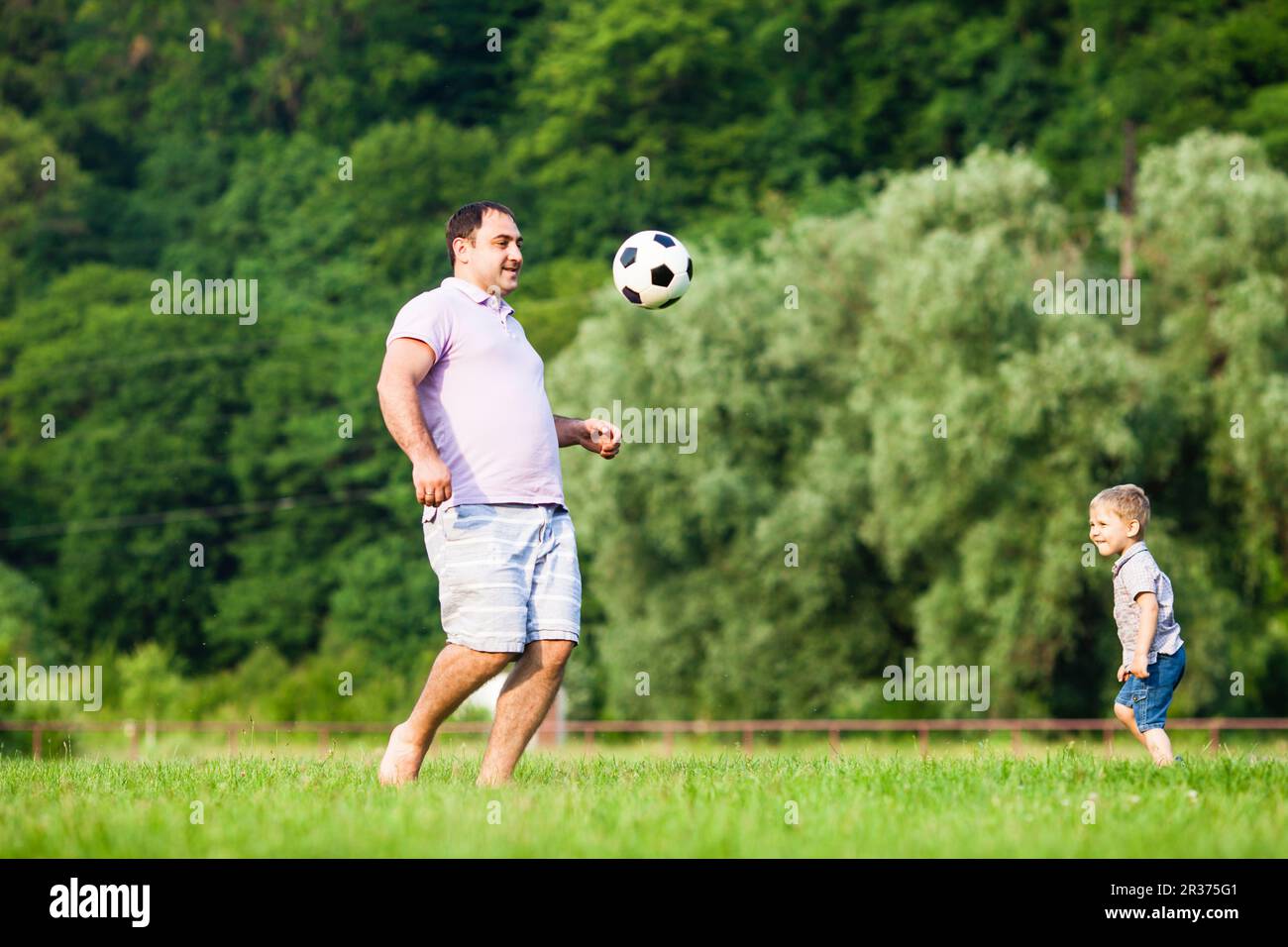 Father and son playing football Stock Photo - Alamy