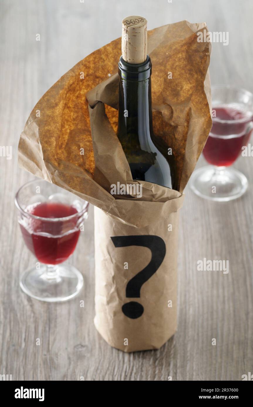 A bottle of red wine in a paper bag with a question mark Stock Photo ...