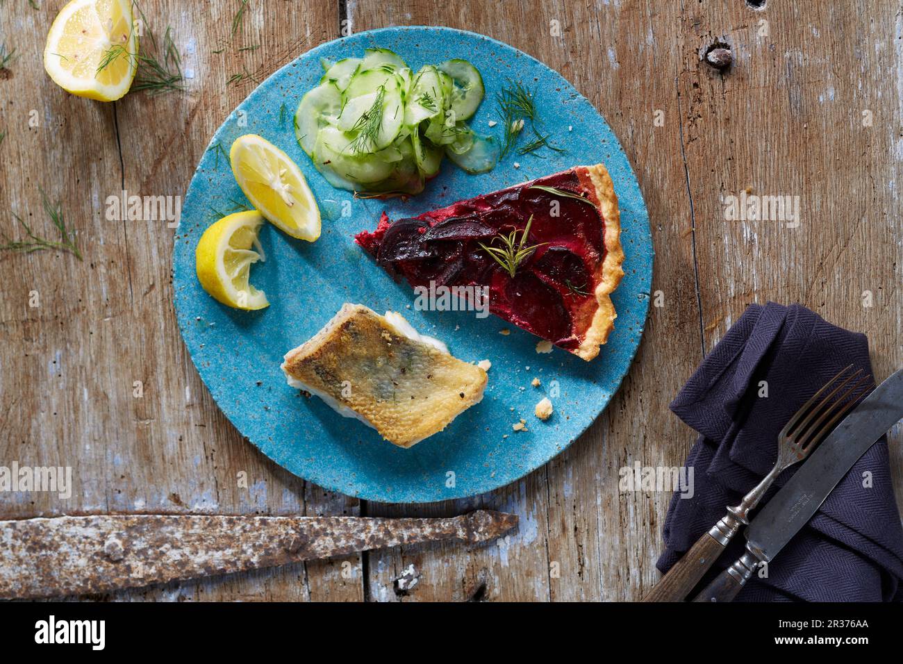 Beetroot quiche, fried fish fillet and cucumber salad Stock Photo - Alamy