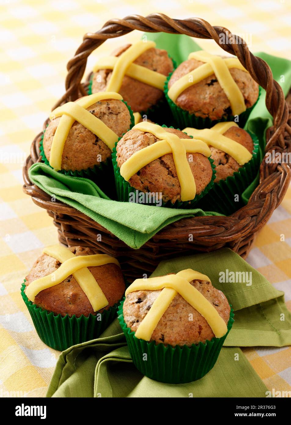 Several Easter muffins with marzipan crosses in a basket and on a ...