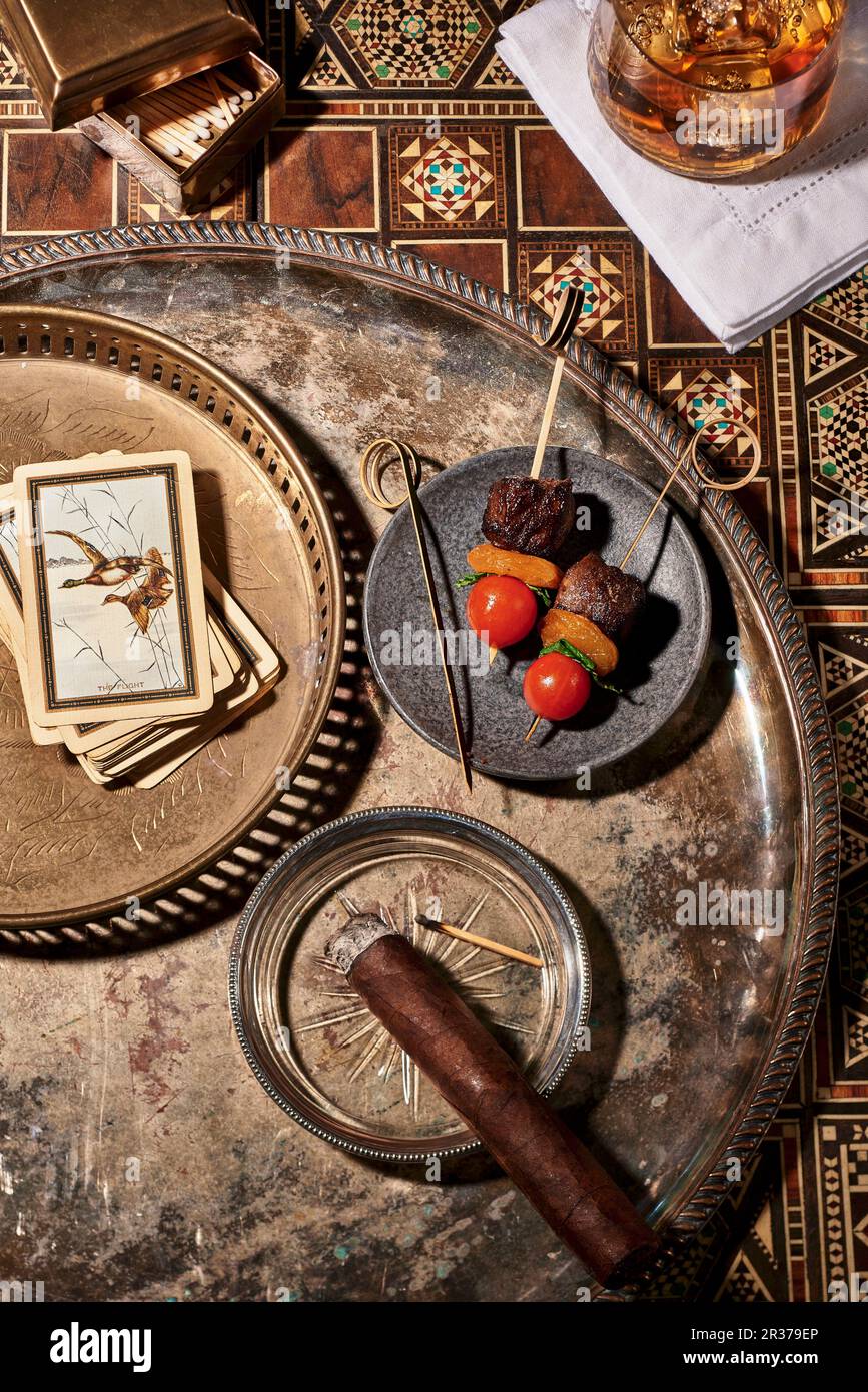 Skewers, cigars and playing cards in a smoking room Stock Photo - Alamy
