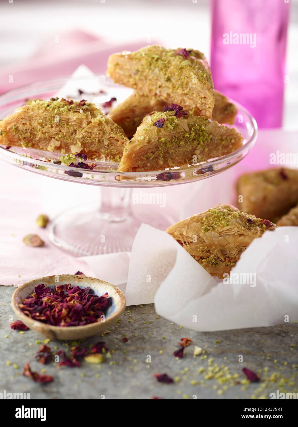 Pistachio baklava with rose petals on cake stand with pink napkin Stock ...