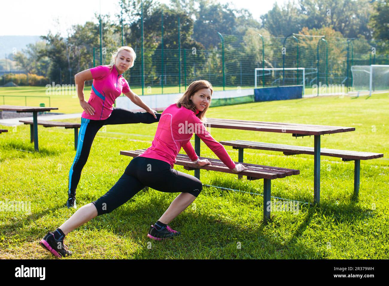 Two women doing stretching exercise Stock Photo - Alamy