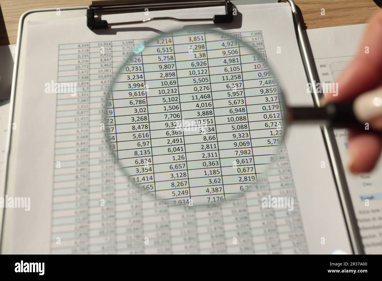 Hand of woman holds magnifier glass over accounting document Stock ...