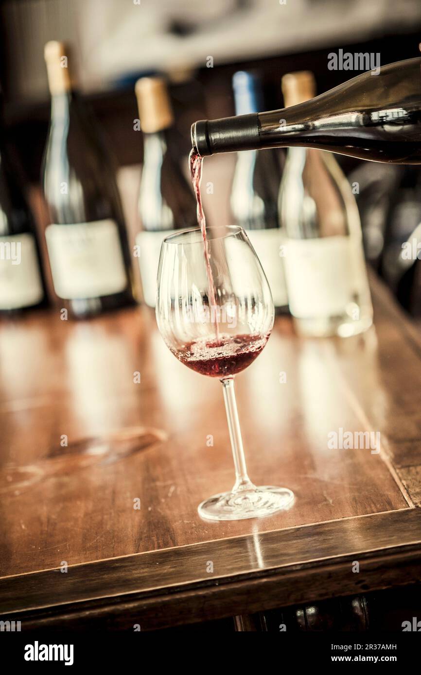 Red wine being poured into a glass Stock Photo - Alamy