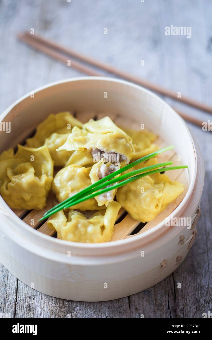 Won tons with chives in a bamboo steamer Stock Photo - Alamy