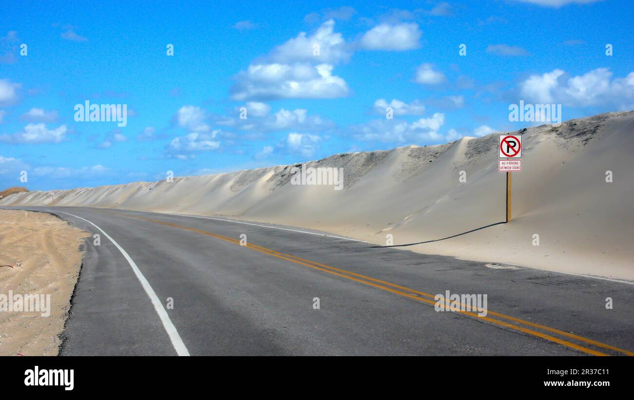 Highway through large sand dunes on the Outer Banks of North Carolina ...