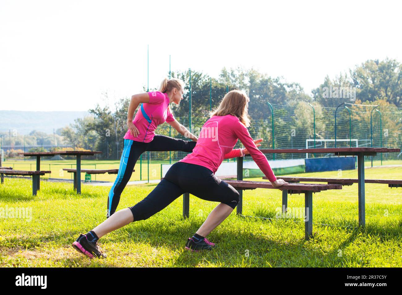 Two women doing stretching exercise Stock Photo - Alamy