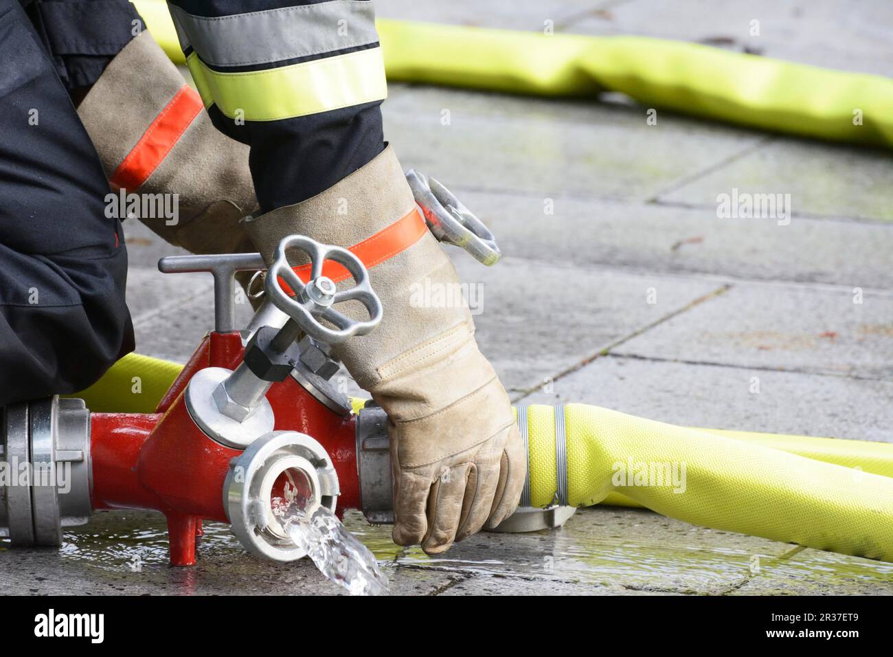 Hand of a fireman connection a firehose to a connector device Stock ...