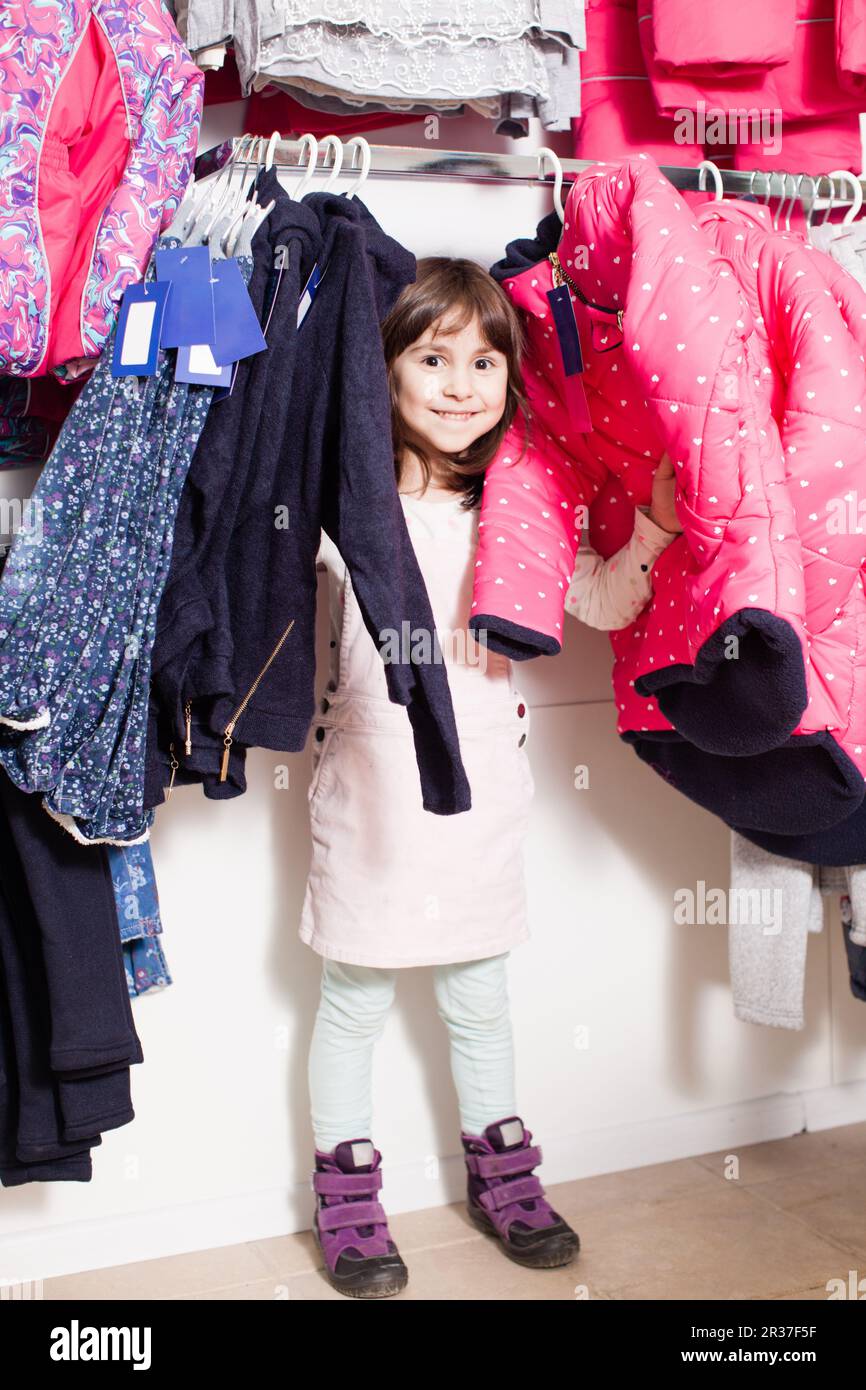 The little girl having fun in clothing store Stock Photo - Alamy
